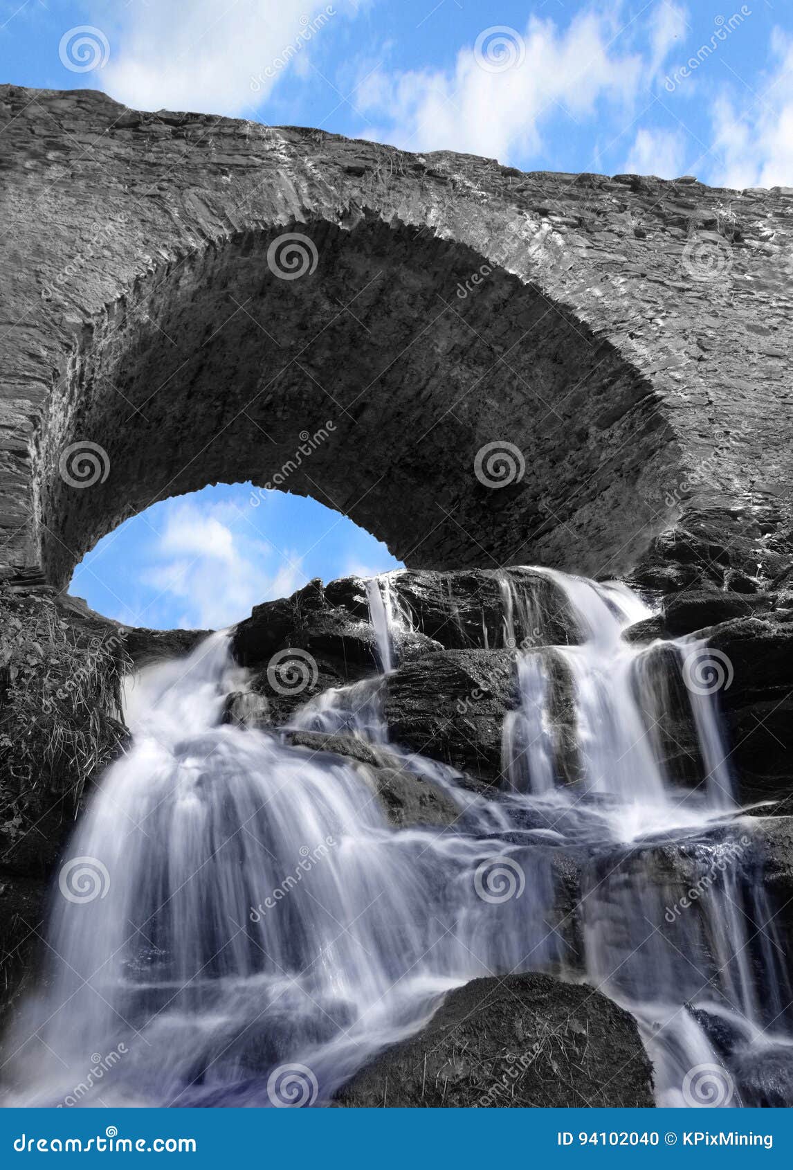 Arched Stone Bridge with a Waterfall and Blue Sky Stock Photo - Image ...