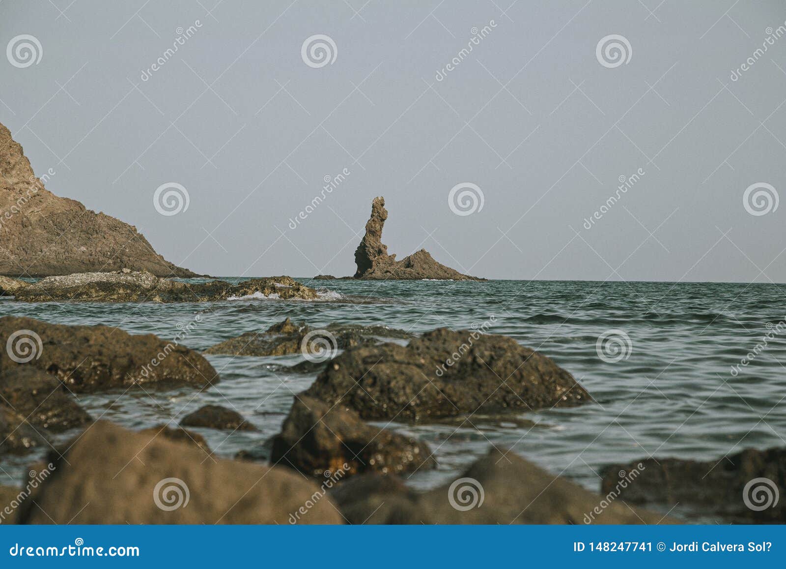 Stone Cove With The Lighthouse At The End In The Ocean Stock ...