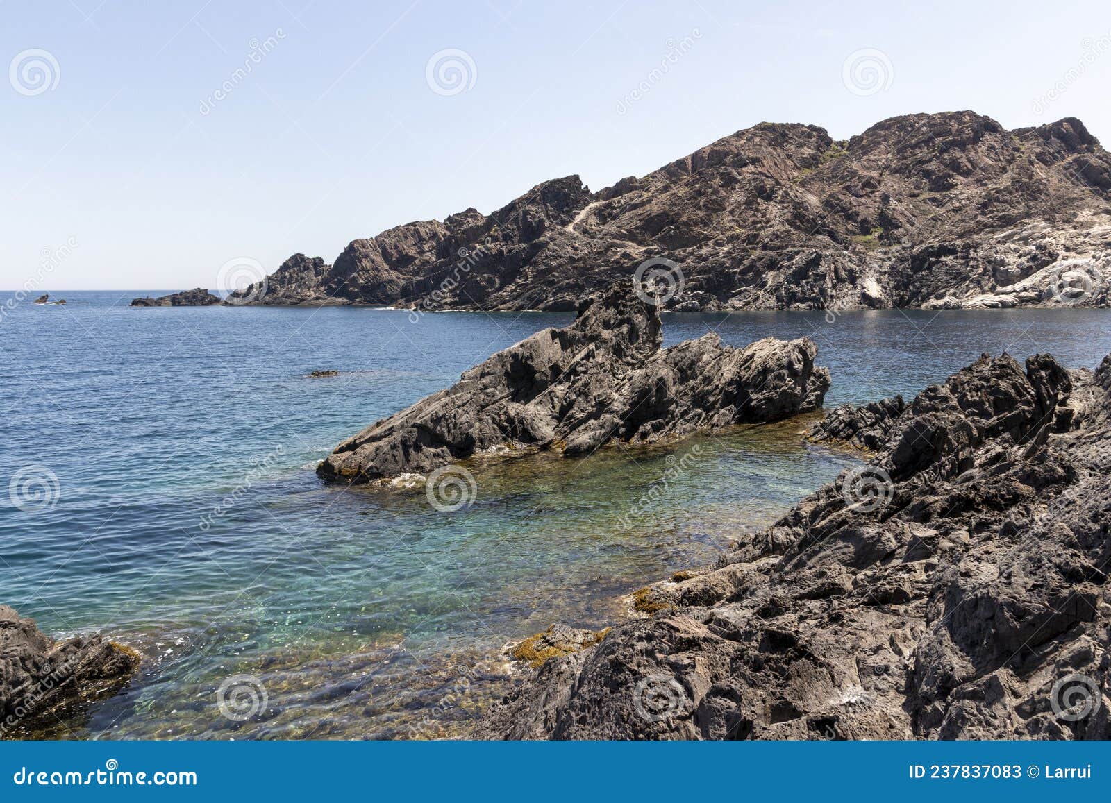 Stone Cove With The Lighthouse At The End In The Ocean Stock ...