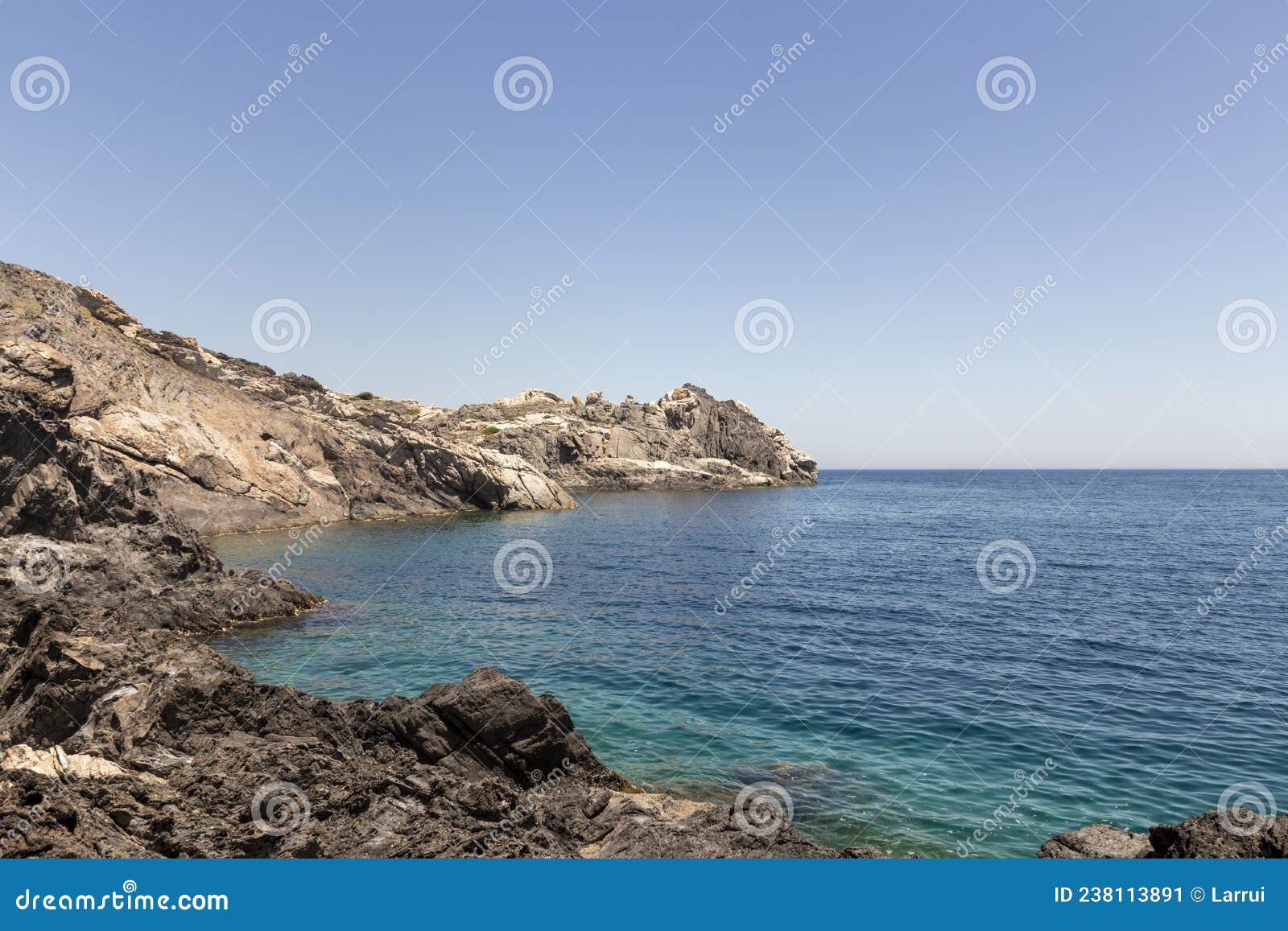 Stone Cove With The Lighthouse At The End In The Ocean Stock ...