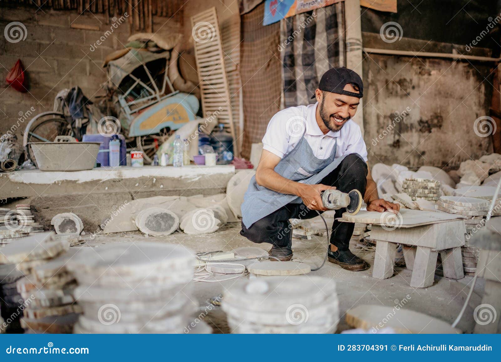 Stone Craft Worker Squats while Cutting Stones Using a Grinder Stock ...