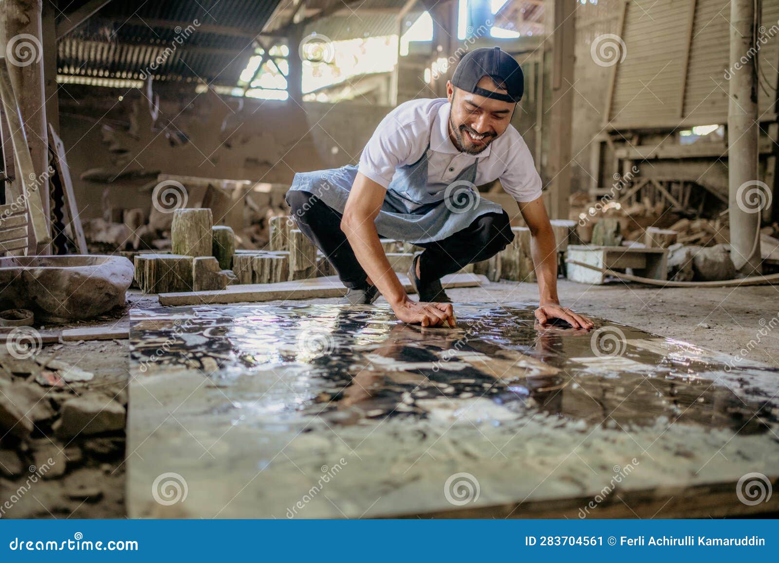 Stone Craftsman Squatting while Washing Large Squares of Stone Stock ...