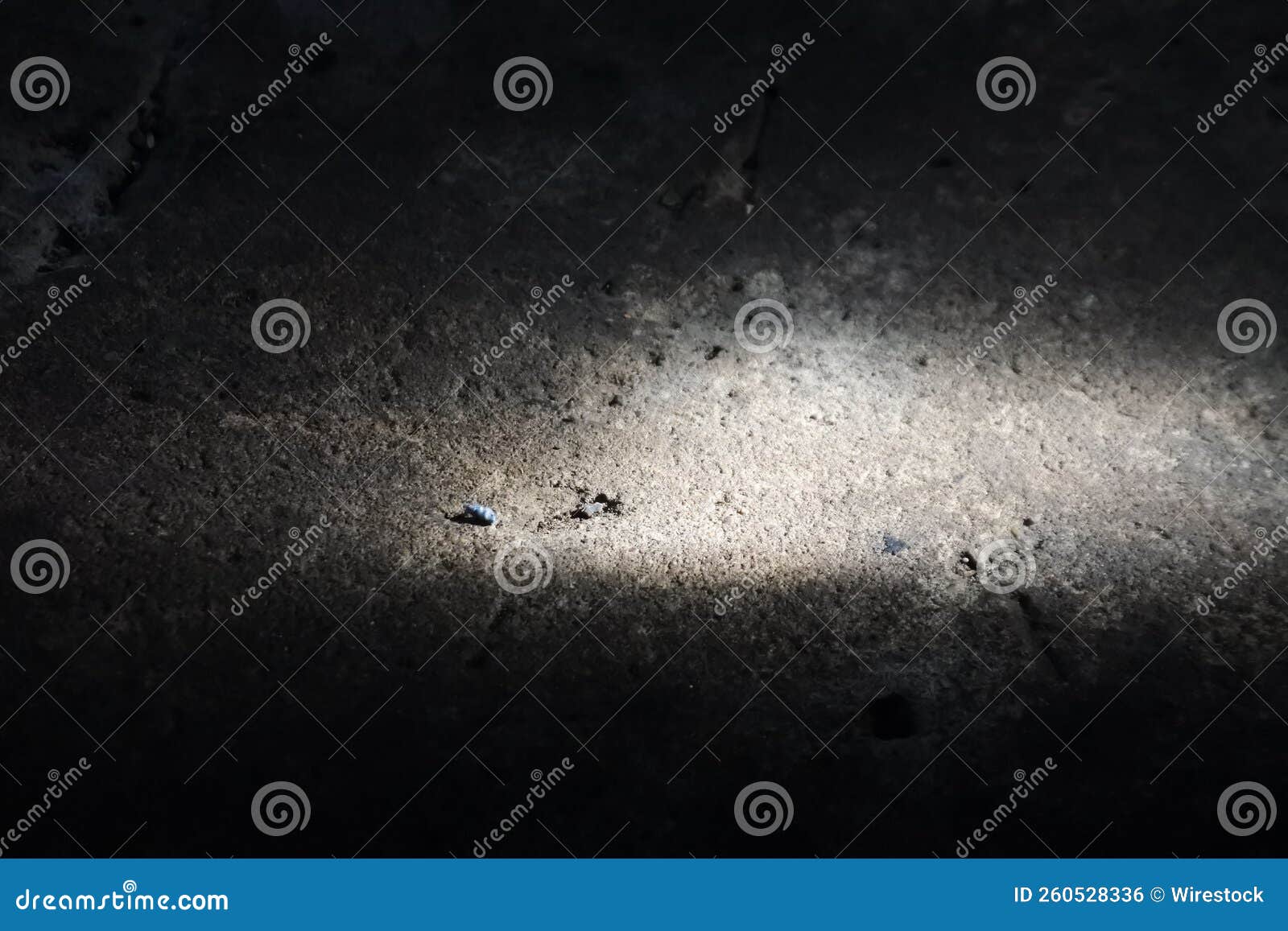 Stone Ground Surface with a Small Beam of Light Surrounded by Darkness ...