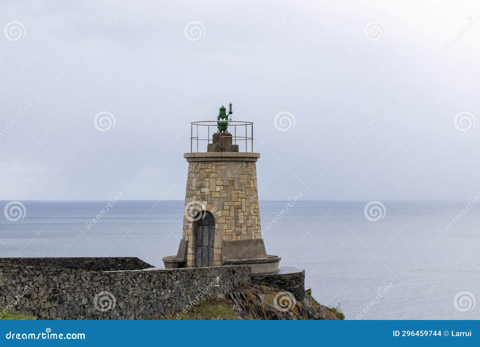 A Stone Lighthouse with a Green Statue on Top, Overlooking the Calm ...