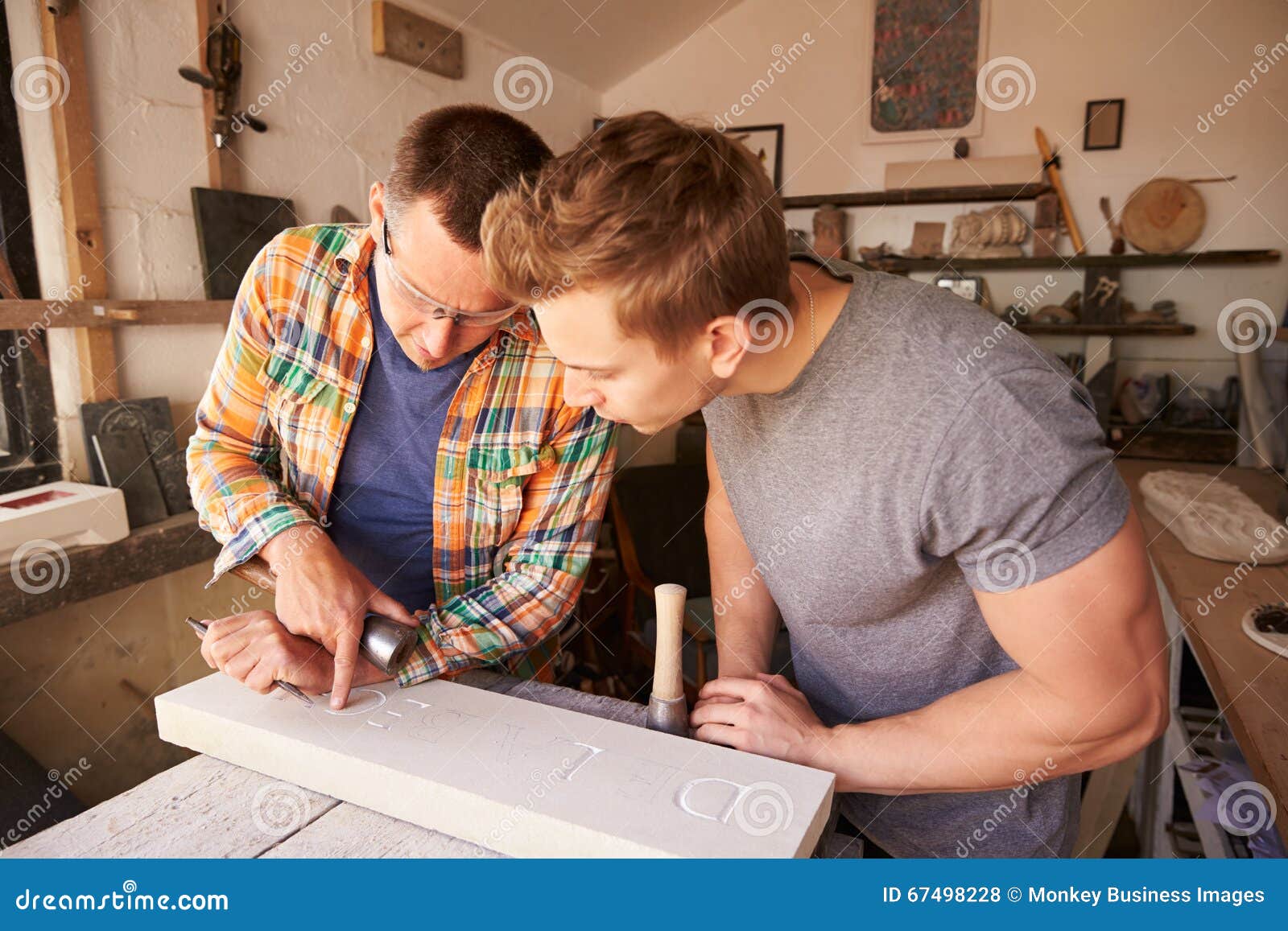 Stone Mason with Apprentice at Work on Carving in Studio Stock Photo ...
