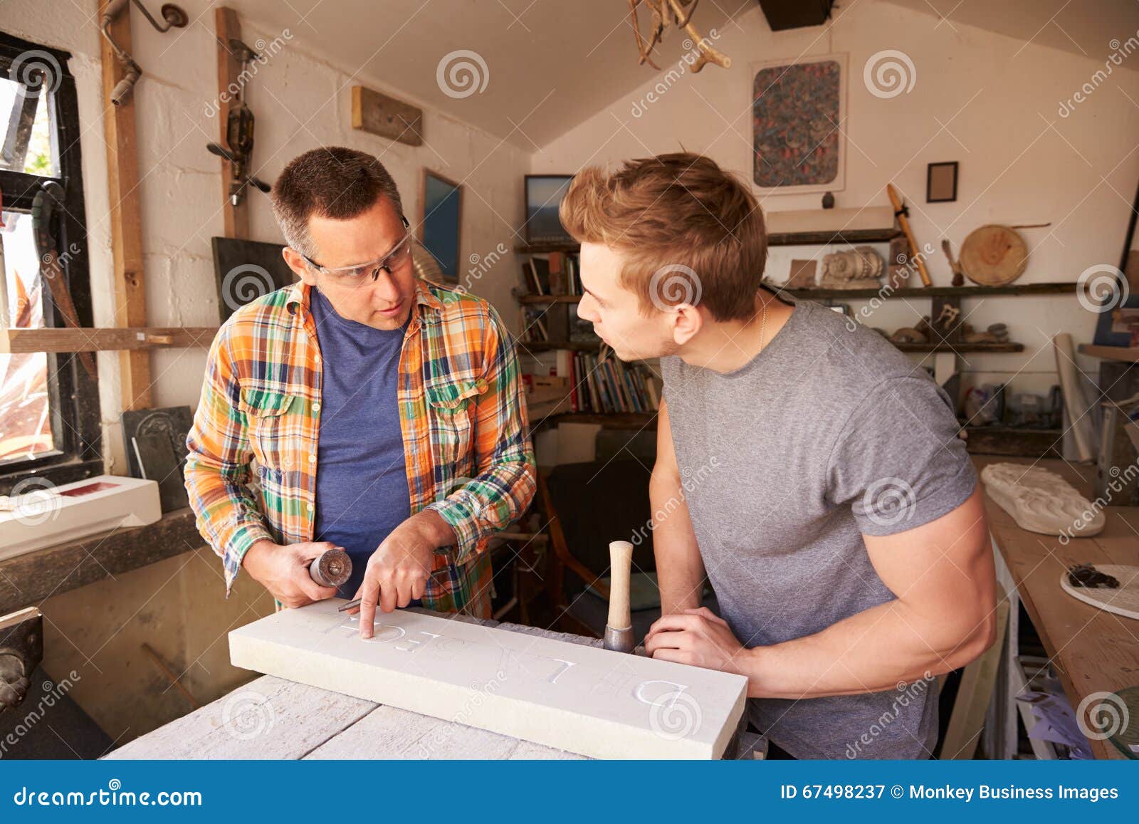 Stone Mason with Apprentice at Work on Carving in Studio Stock Image ...