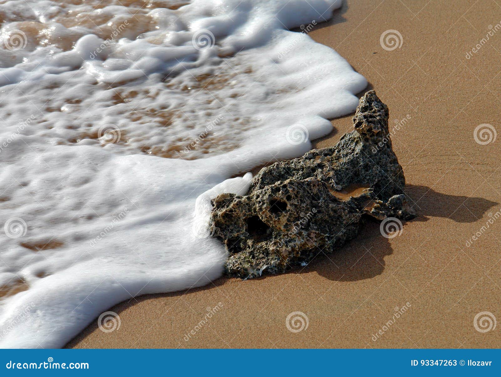 Stone in the Sand and a Wave Stock Image - Image of detail, close: 93347263