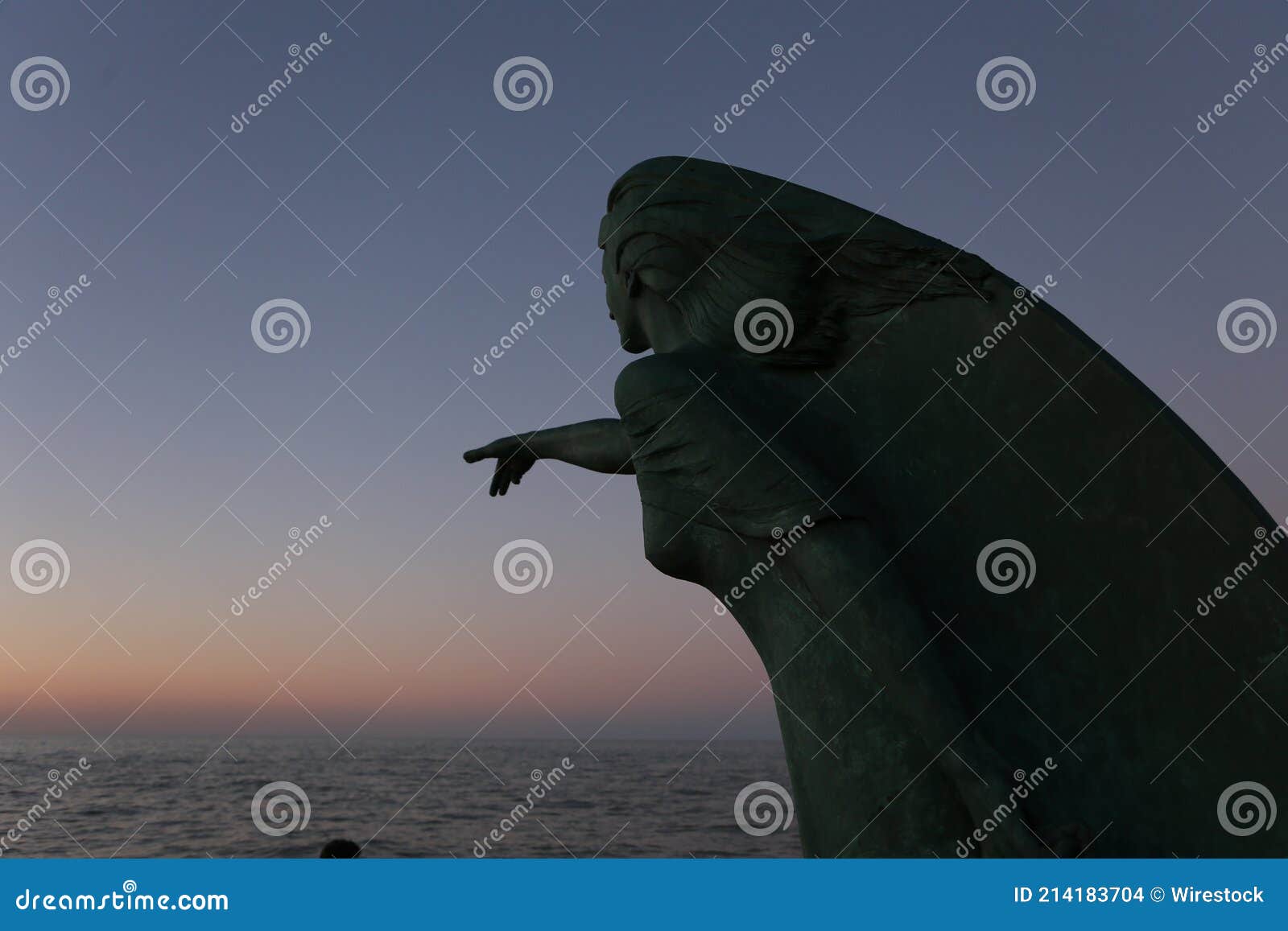Stone Statue Pointing at the Horizon at Sunset Stock Photo - Image of ...