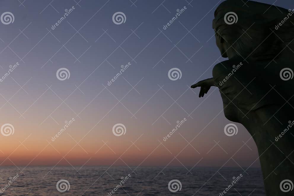 Stone Statue Pointing at the Horizon at Sunset Stock Photo - Image of ...