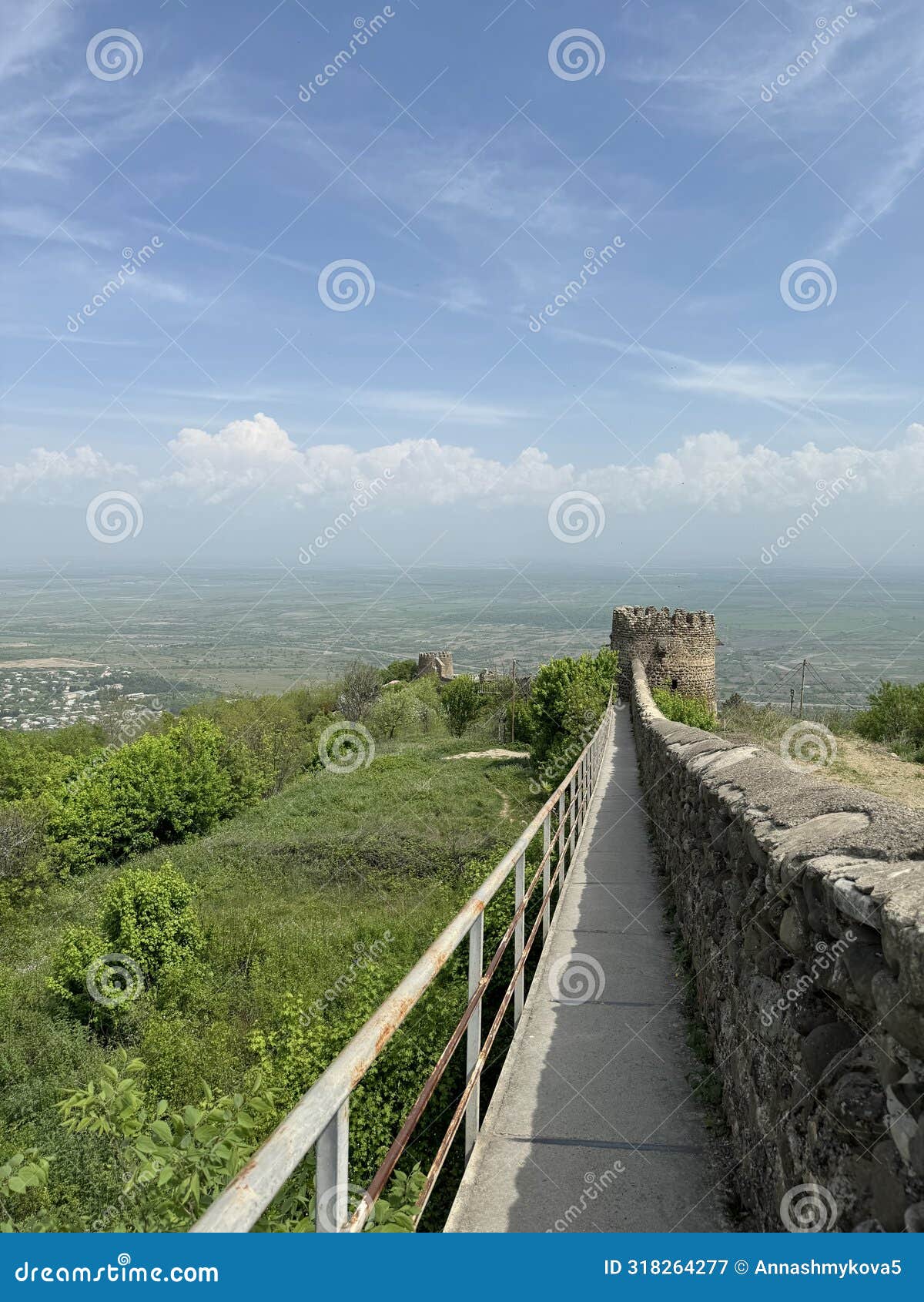 A Stone Wall with a Railing with Small Tower and Valley View on the ...