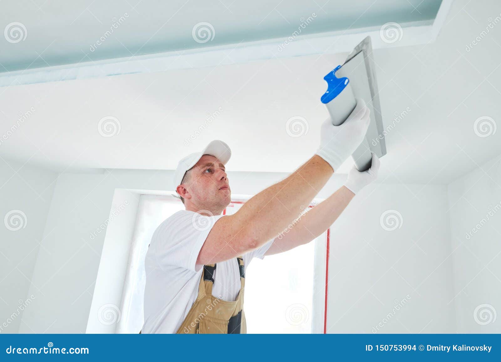 Painter with Putty Knife. Plasterer Smoothing Ceiling Surface at Home ...