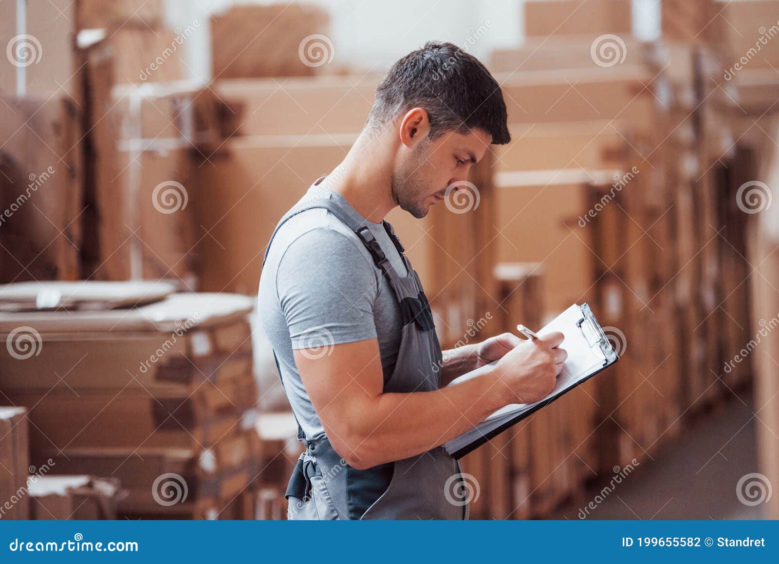 Storage Worker in Uniform and Notepad in Hands Checks Production Stock ...