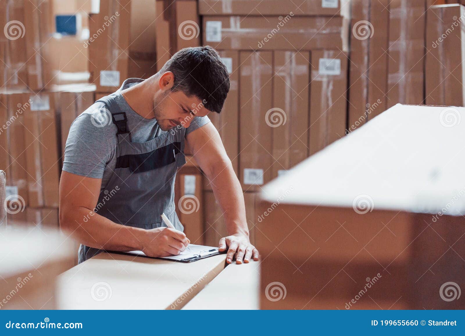 Storage Worker in Uniform and Notepad in Hands Checks Production Stock ...