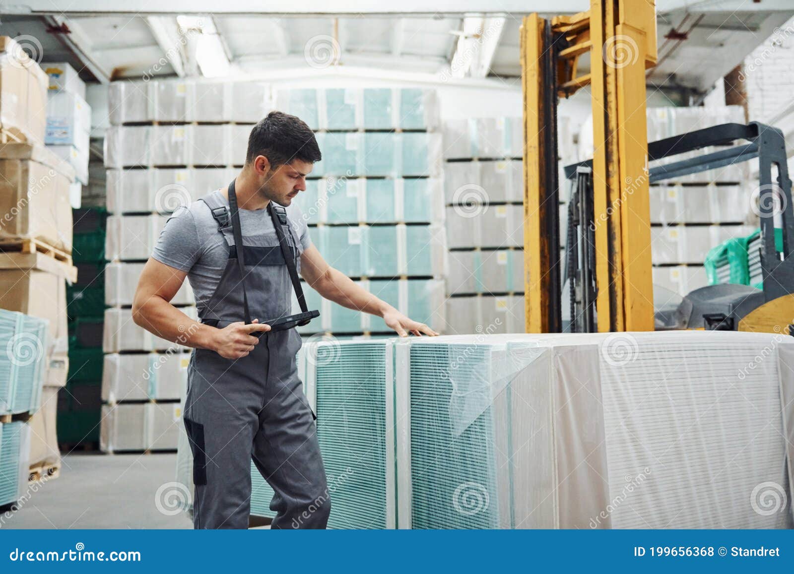 Storage Worker in Uniform and Tablet in Hands Checks Production Stock ...