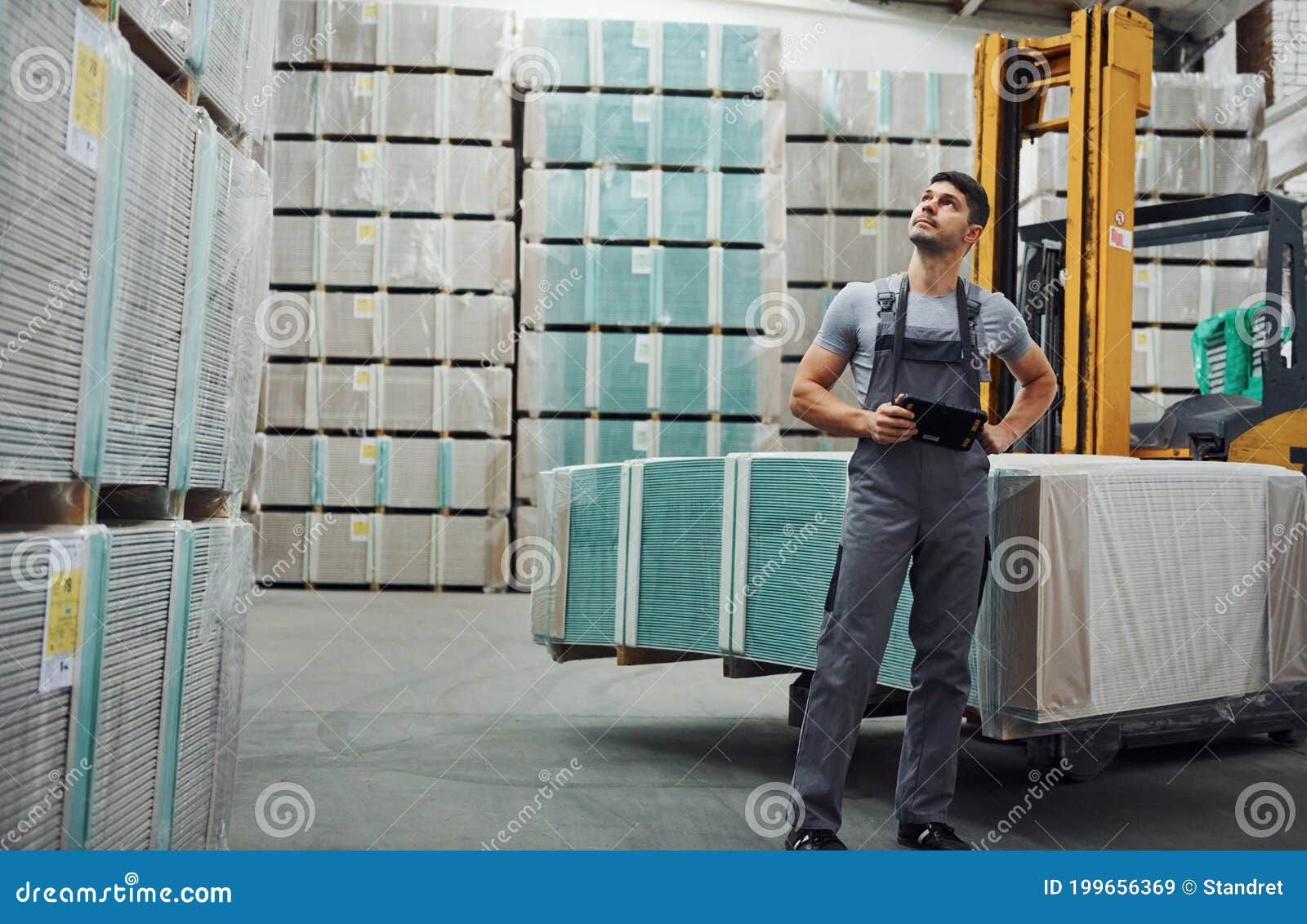 Storage Worker in Uniform and Tablet in Hands Checks Production Stock ...