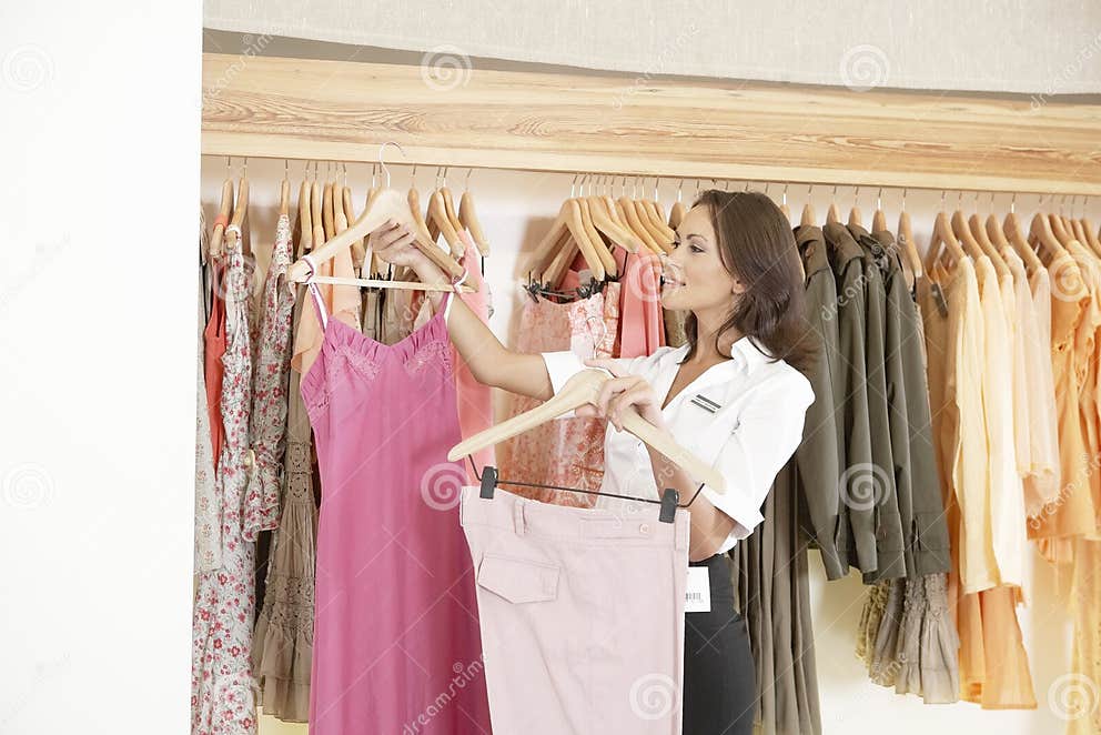 Store Assitant Working and Hanging Clothes in Store Stock Photo - Image ...
