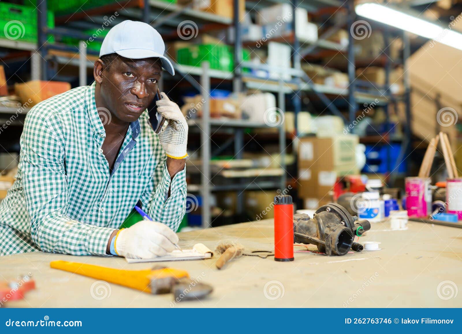 Storehouse Worker Standing at Workbench and Having Telephone ...