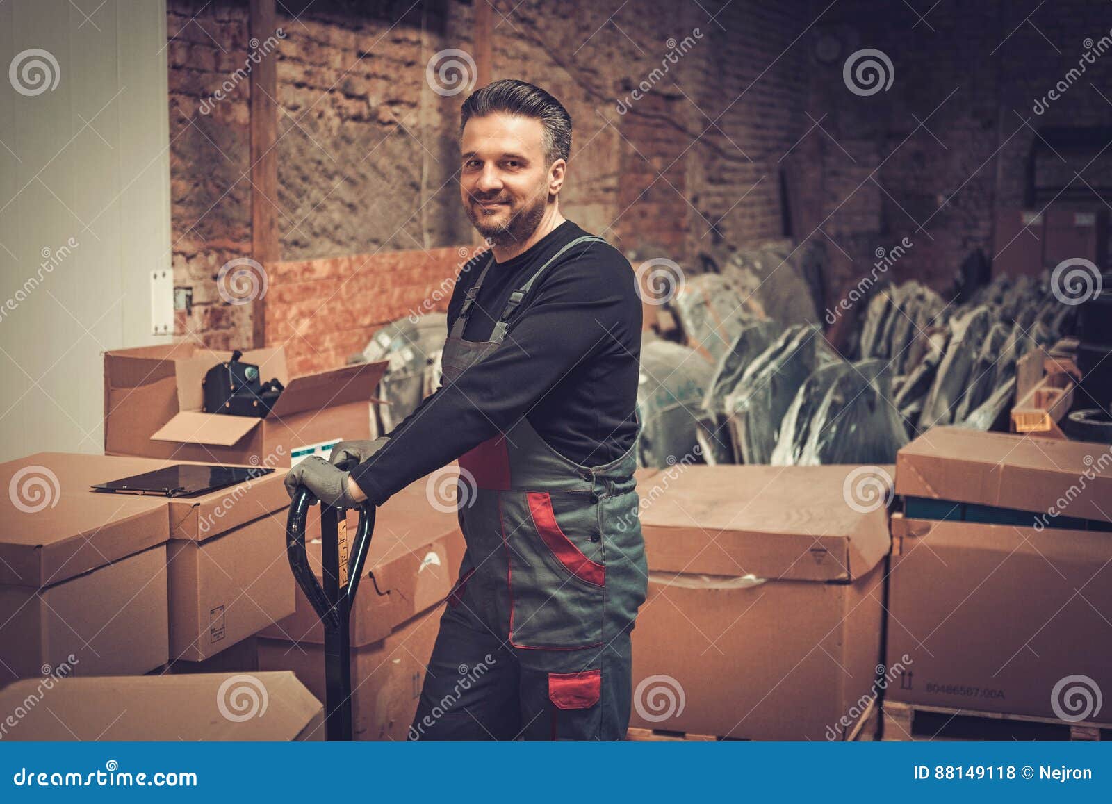Storekeeper Working with Pallet Truck in a Warehouse Stock Photo ...