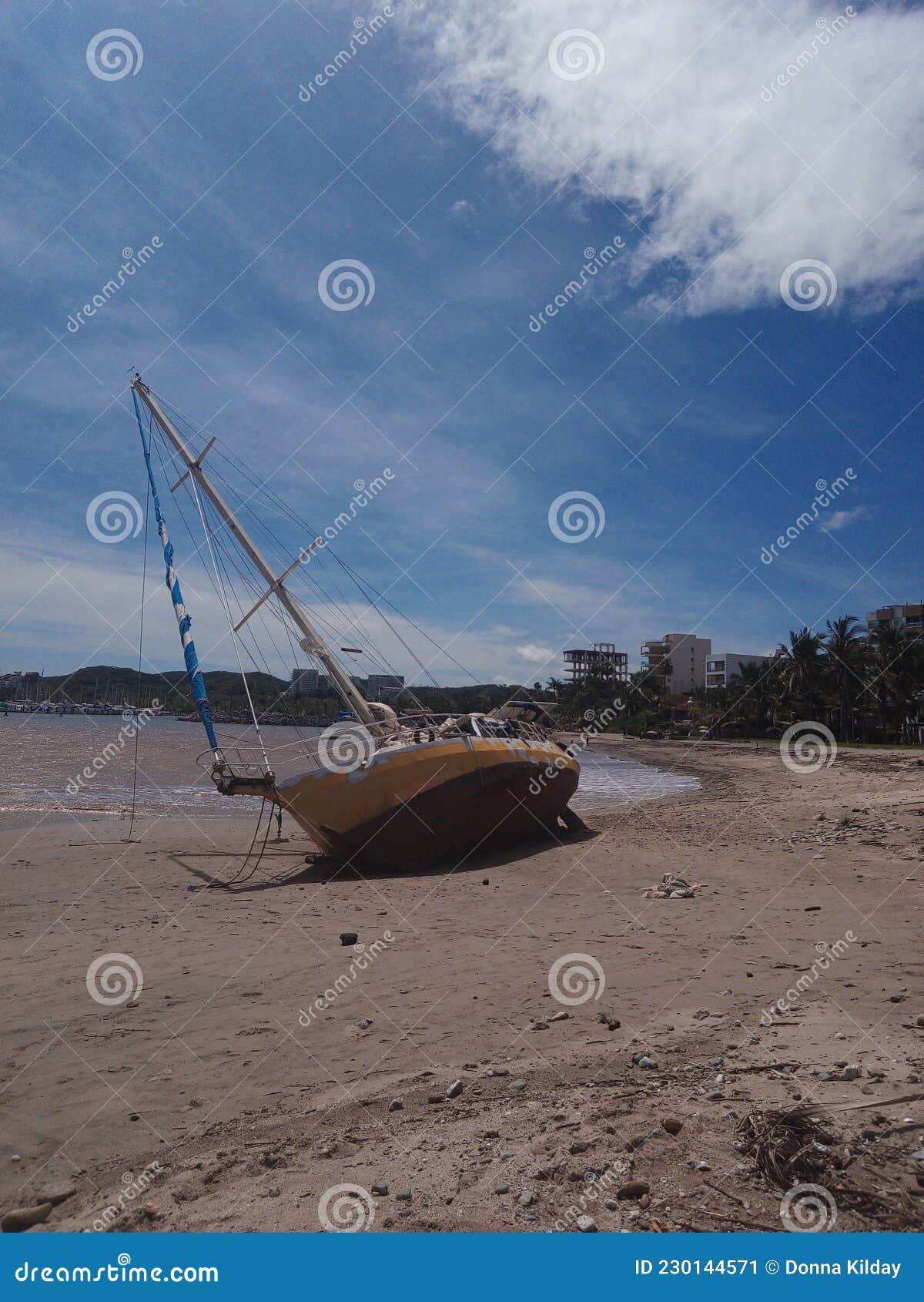 Stranded sailboat on beach stock image. Image of wave - 230144571