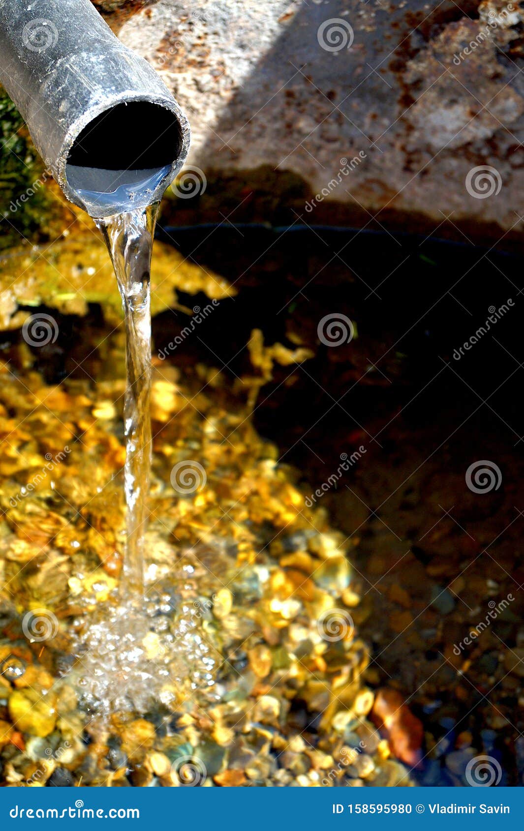 A Stream of Pure Water Flows Out of the Pipe and the Bright Sun Shines ...