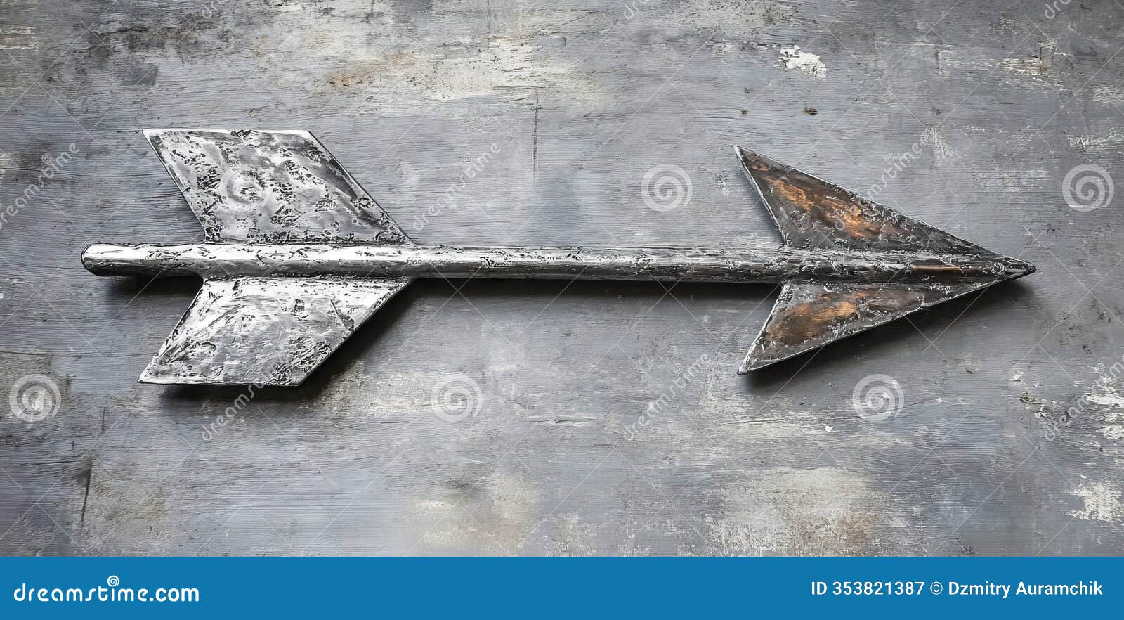 A Streamlined Metal Arrow Facing Left on a Textured Surface, Indicating ...