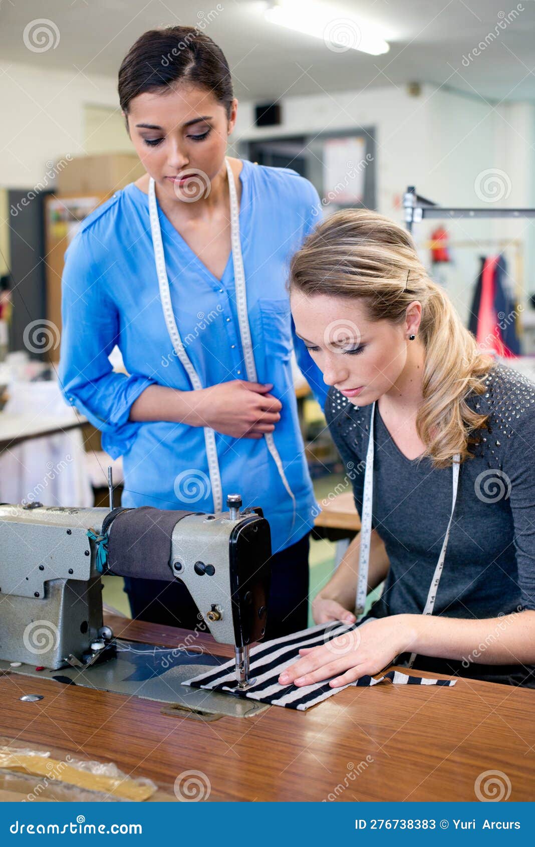 Streamlined Sewing at the Workbench. Two Young Women Working on a ...