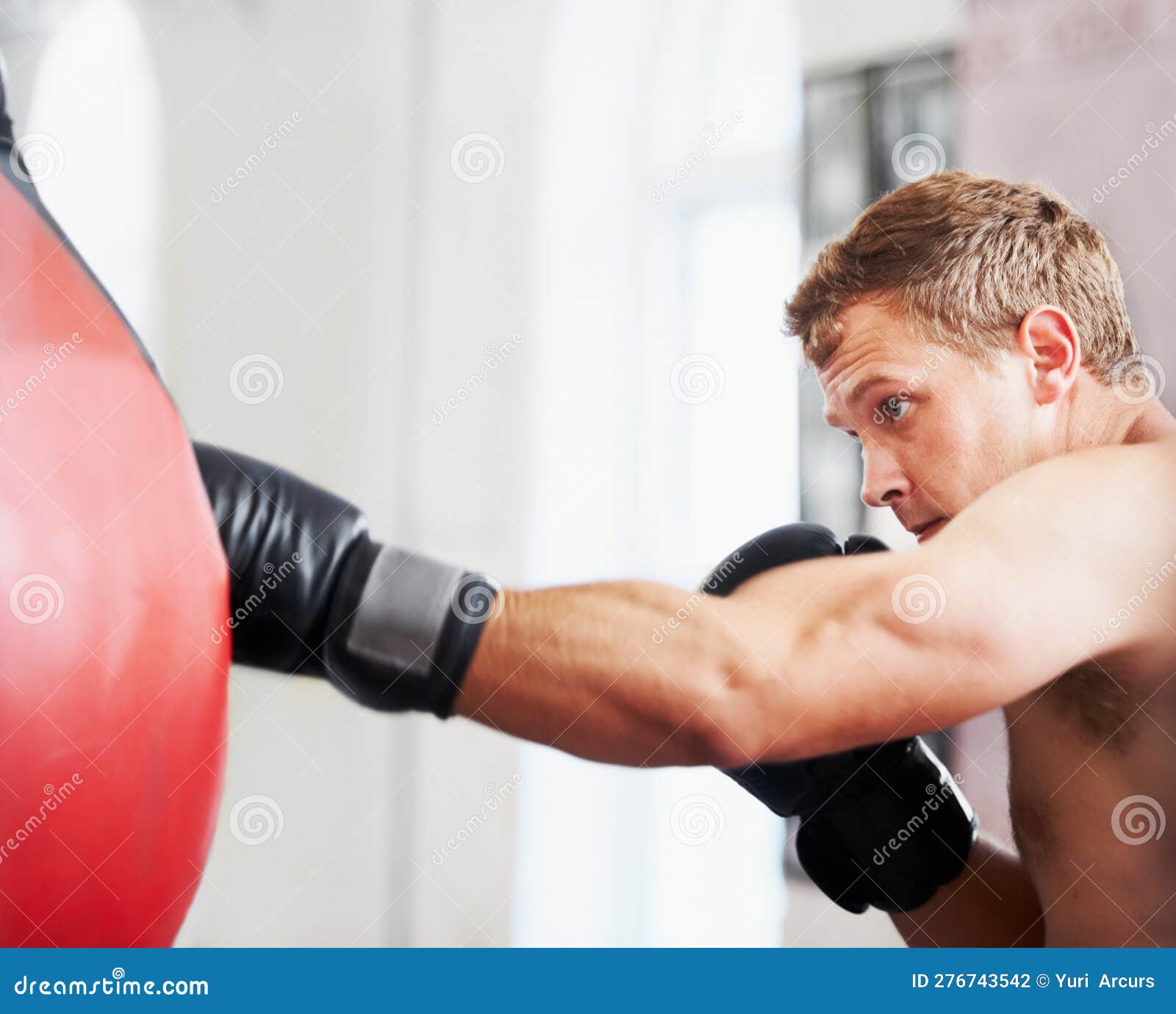 Strength and Focus. a Young Boxer Practicing with a Punching Ball ...