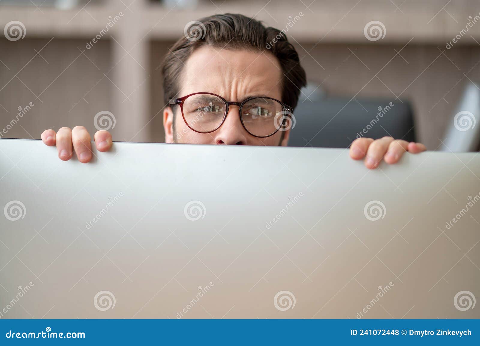 A Dark-haired Man Hiding Behind the Computer and Looking Stressed Stock ...