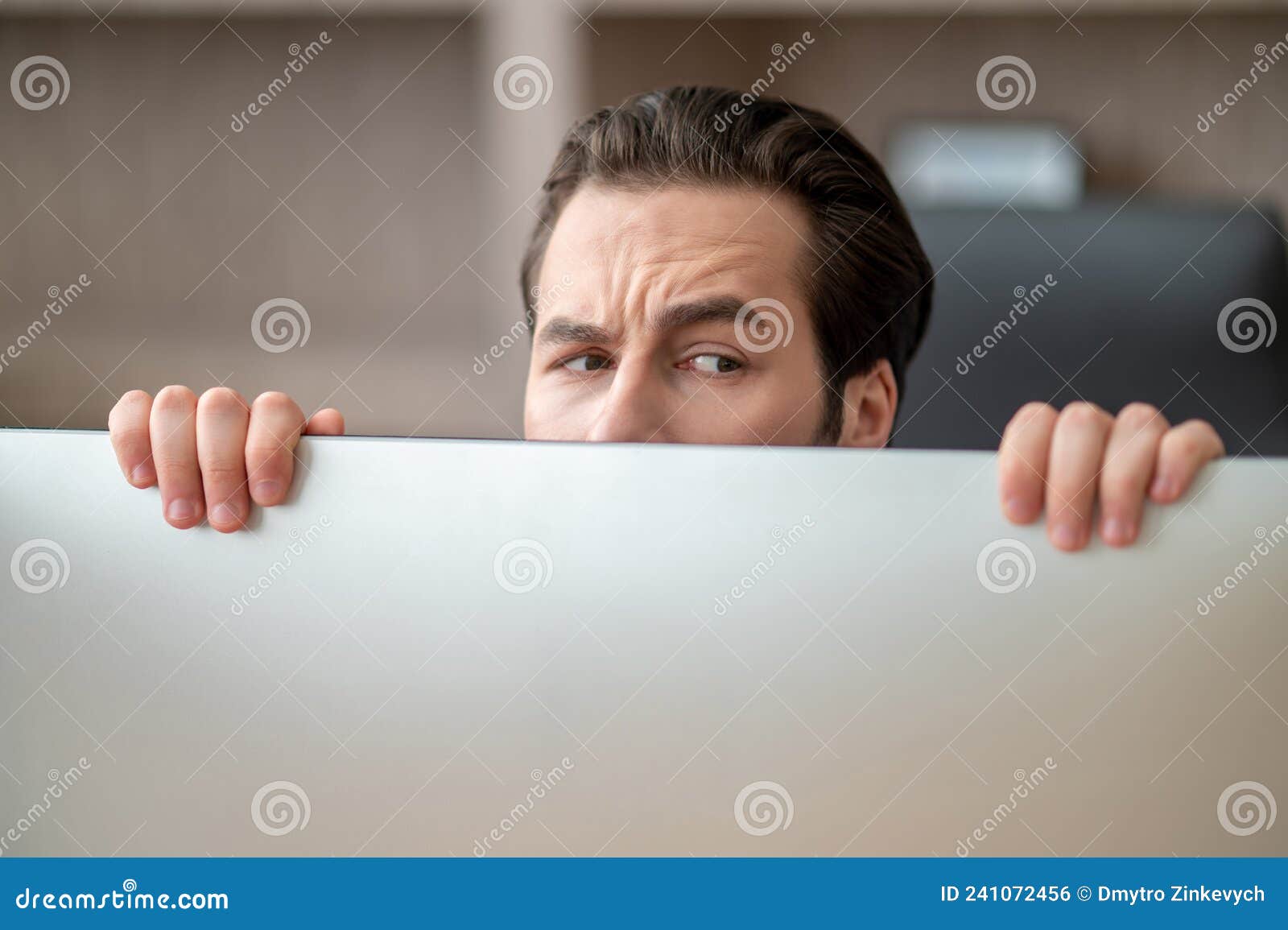 A Dark-haired Man Hiding Behind the Computer and Looking Stressed Stock ...