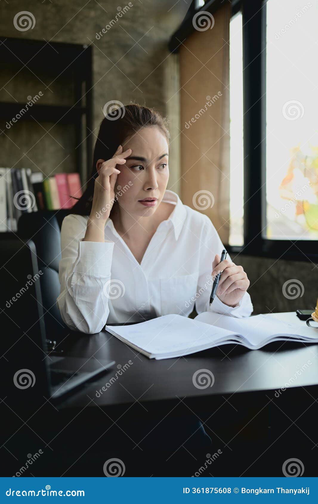 A Stressed Asian Female Architect or Engineer Boss Sits at Her Desk in ...