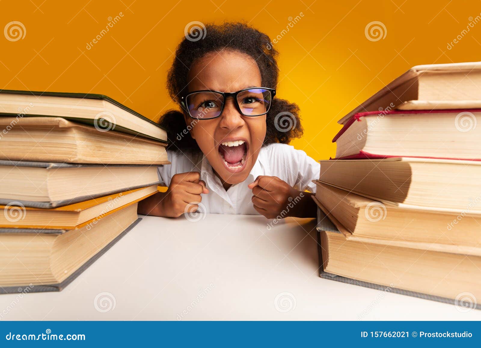 Elementary School Girl Yelling Sitting between Book Stacks in Studio ...