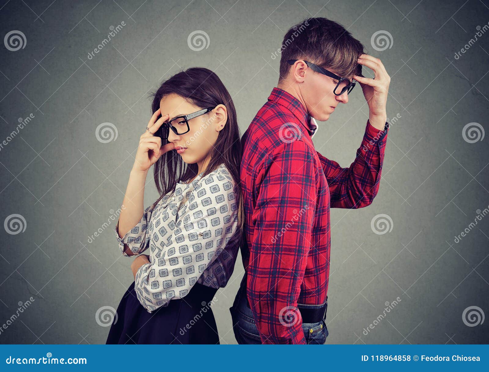 Stressed Couple with Hand on Head Standing Back To Back Looking Down in ...