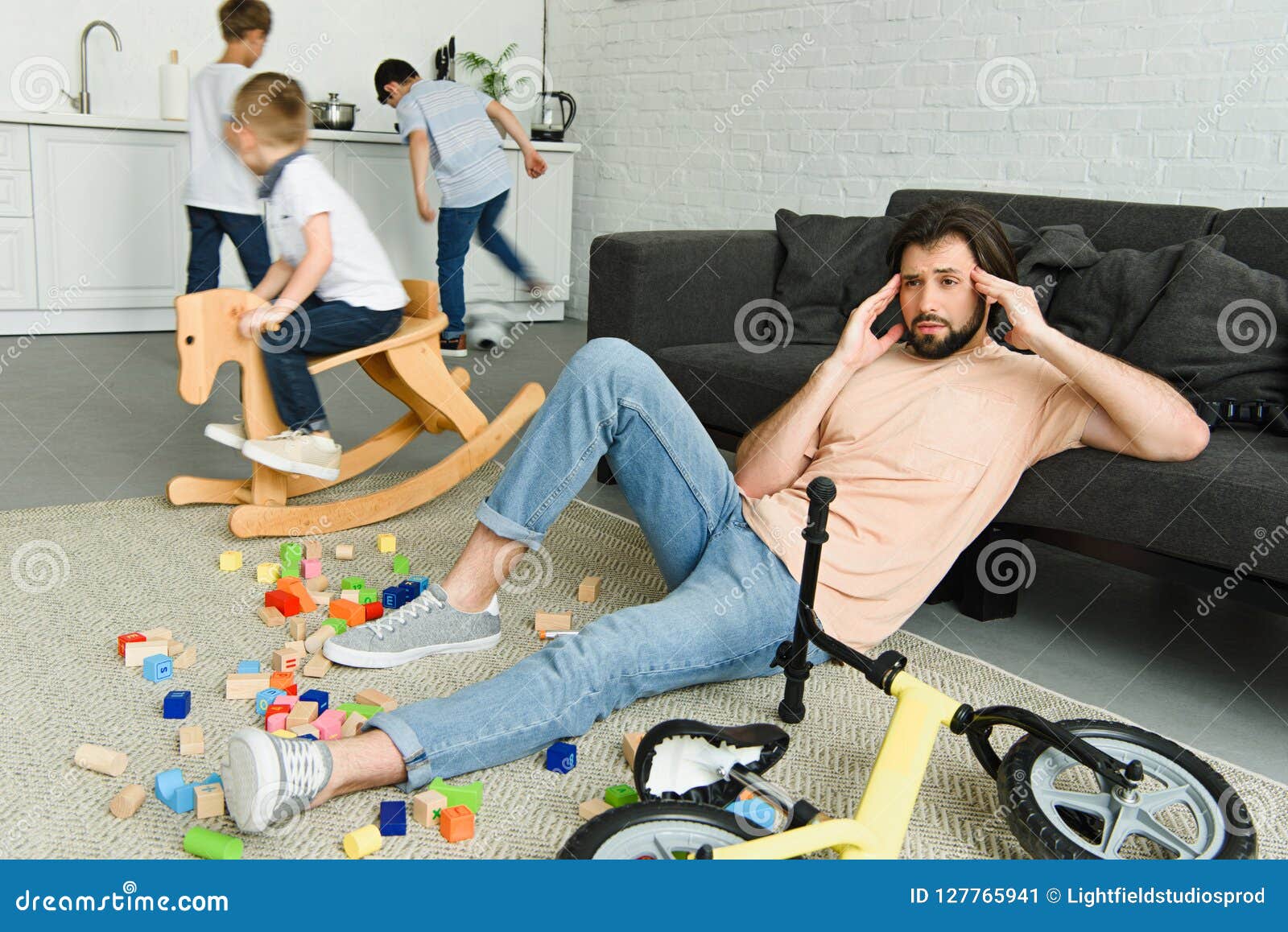 Stressed Father Sitting on Floor and Kids Playing Around Stock Image ...
