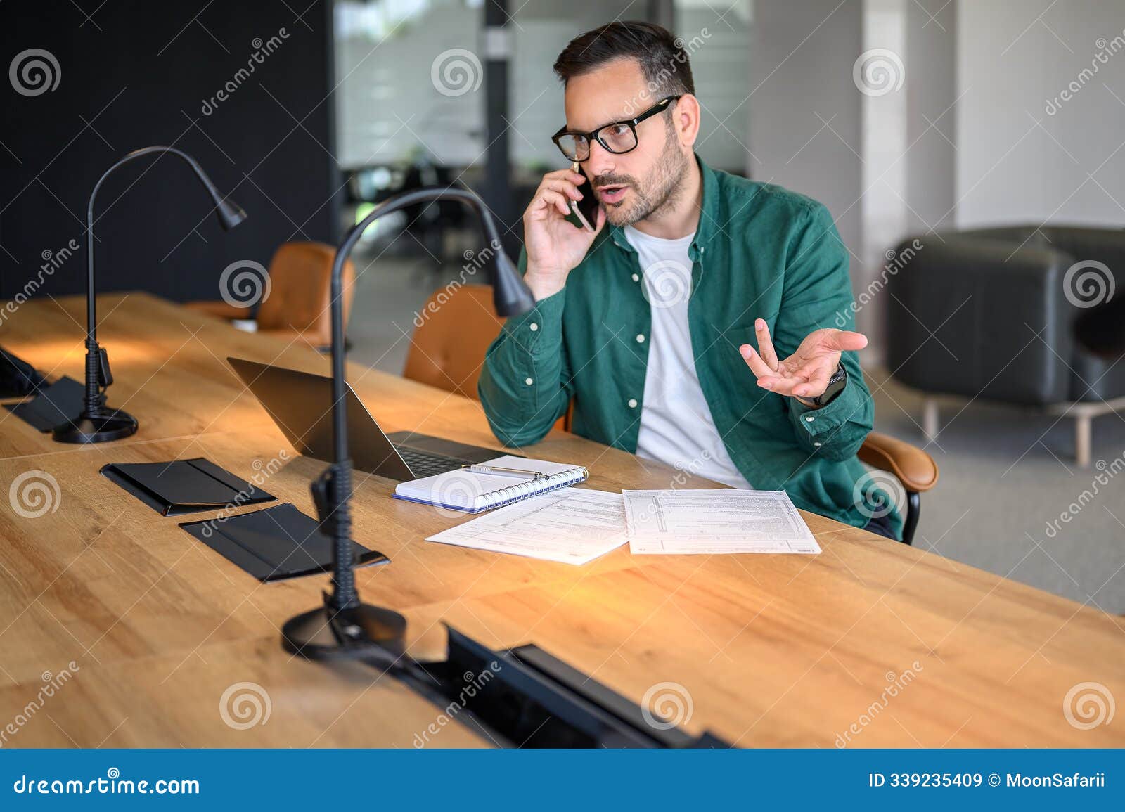 Stressed Male Developer Discussing Over Smart Phone while Working on ...