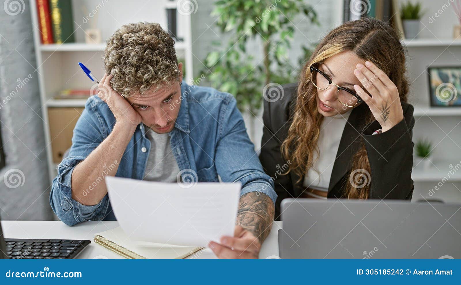 A Stressed Man and Woman Evaluate a Document Together in a Modern ...