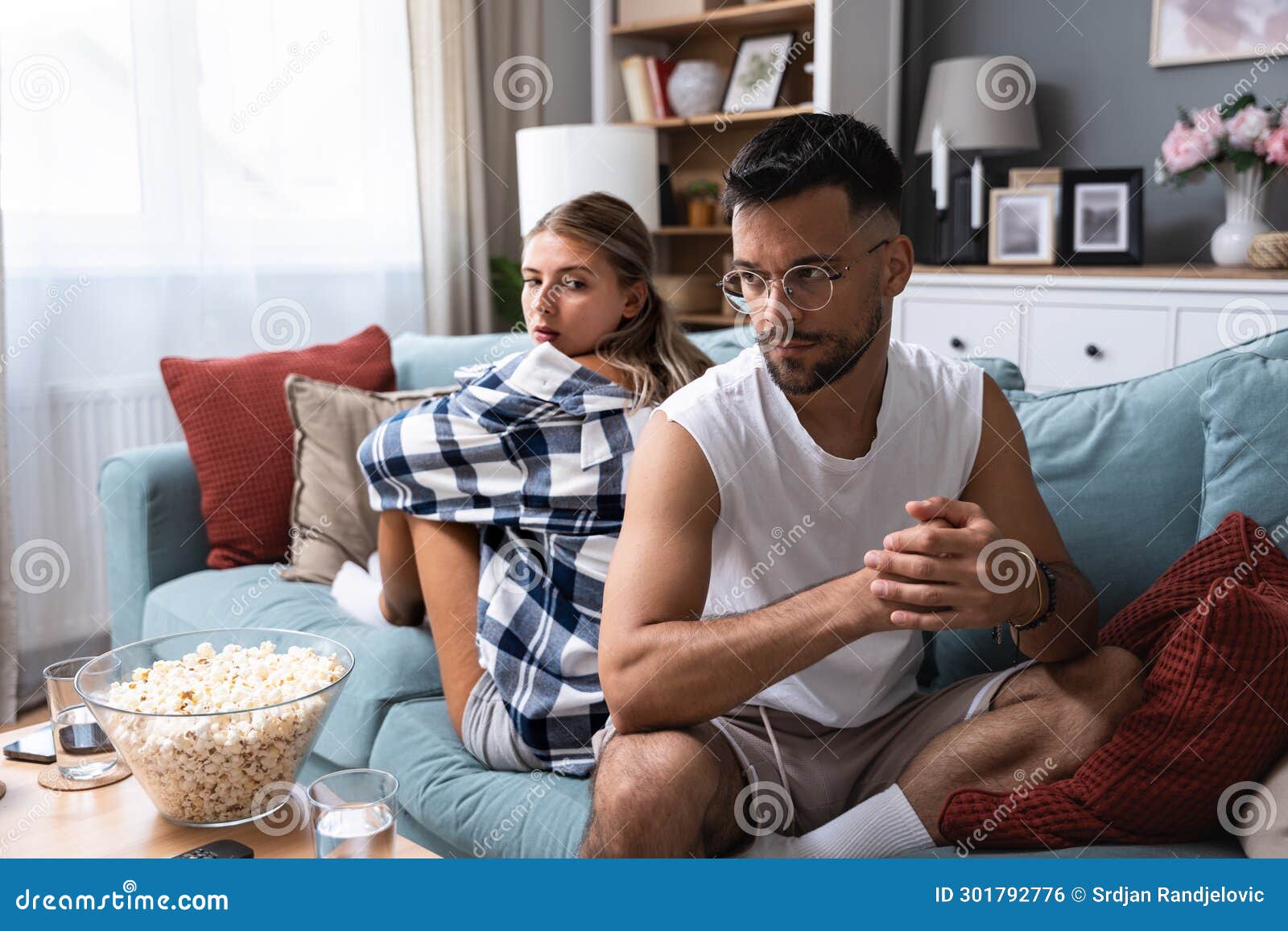 Stressed Young Married Couple Sitting Separately On Different Sides Of