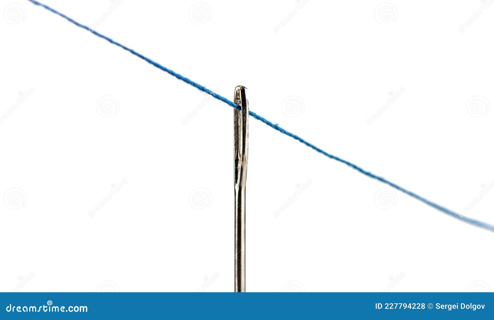Stretched Blue Thread through the Eye of a Needle Over a White ...