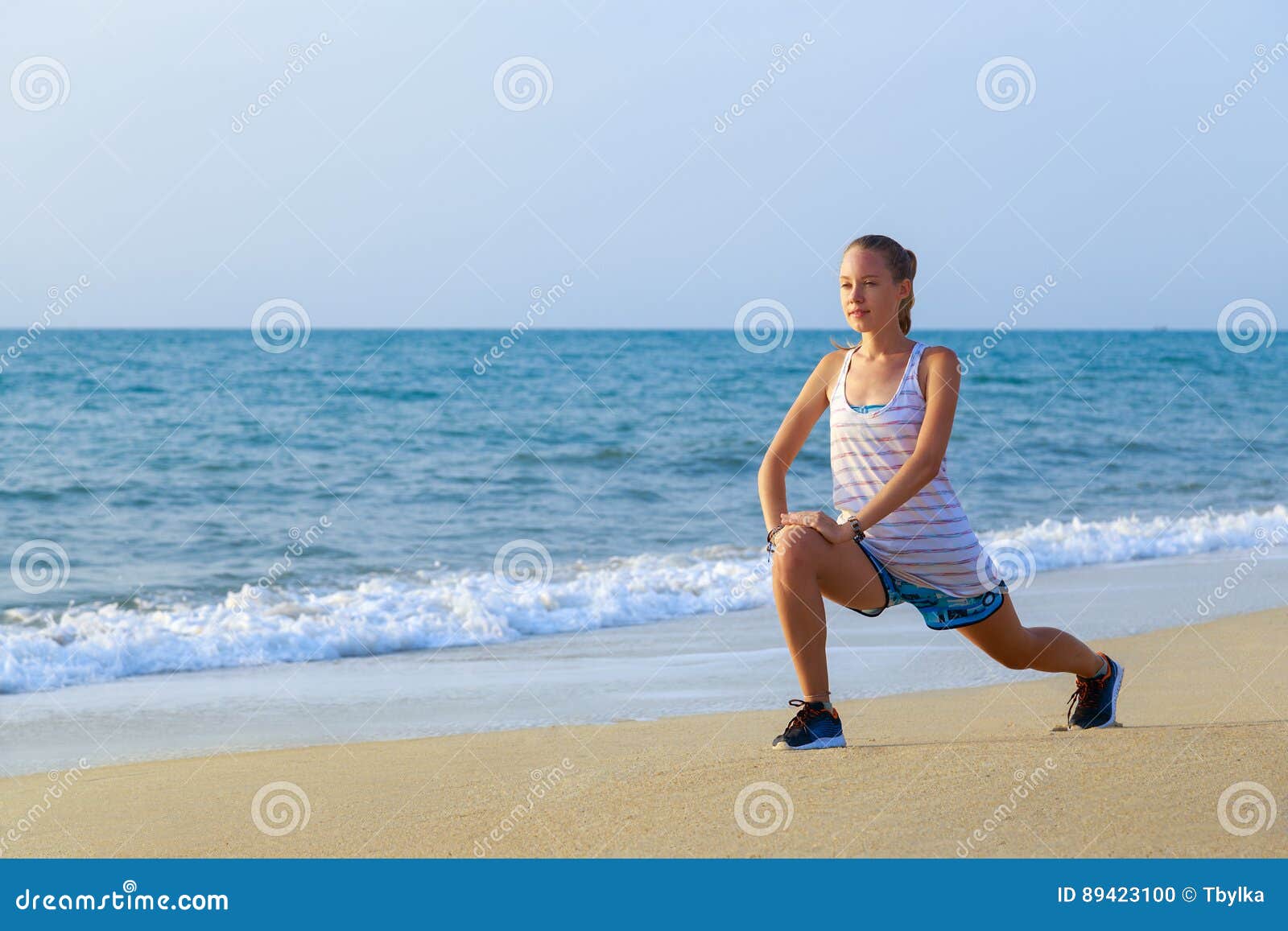 Stretching on the beach stock photo. Image of athletic - 89423100