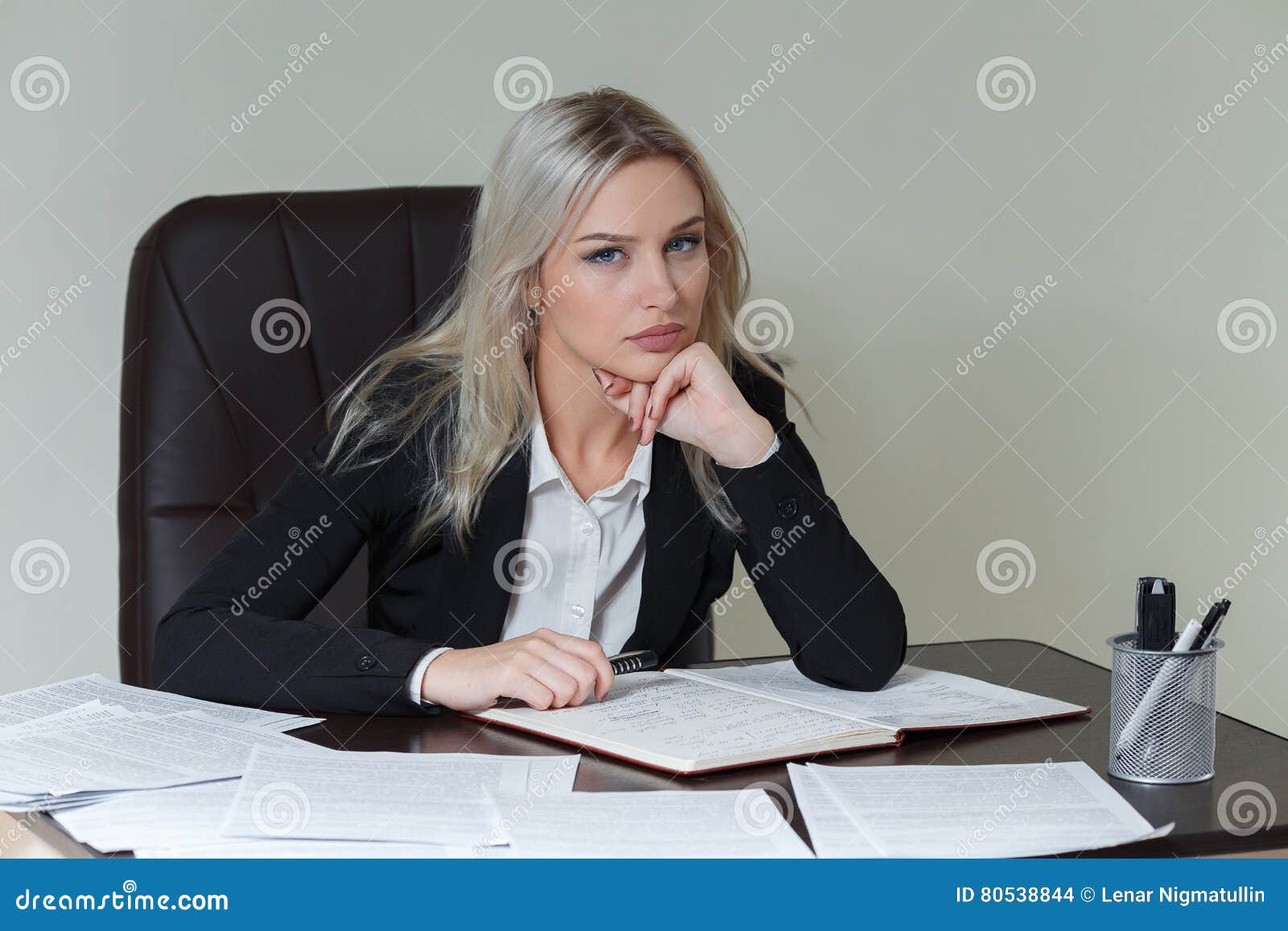 Strict Businesswoman in Suit Sitting at the Table with Documents. Stock ...
