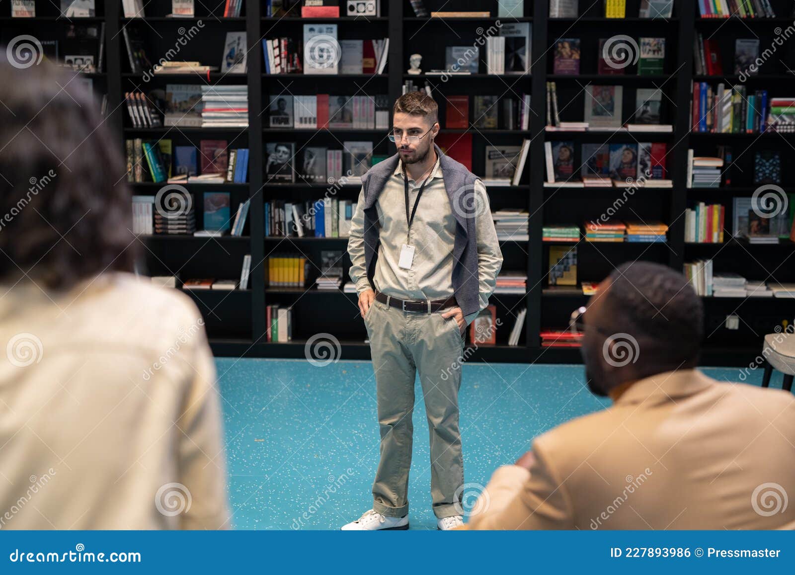 Strict Young Teacher or Coach Standing in Front of Intercultural ...