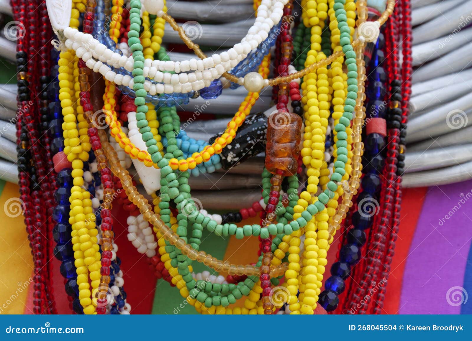 Strings of Colorful Glass Beads Hanging Infront of a Piece Colorful ...