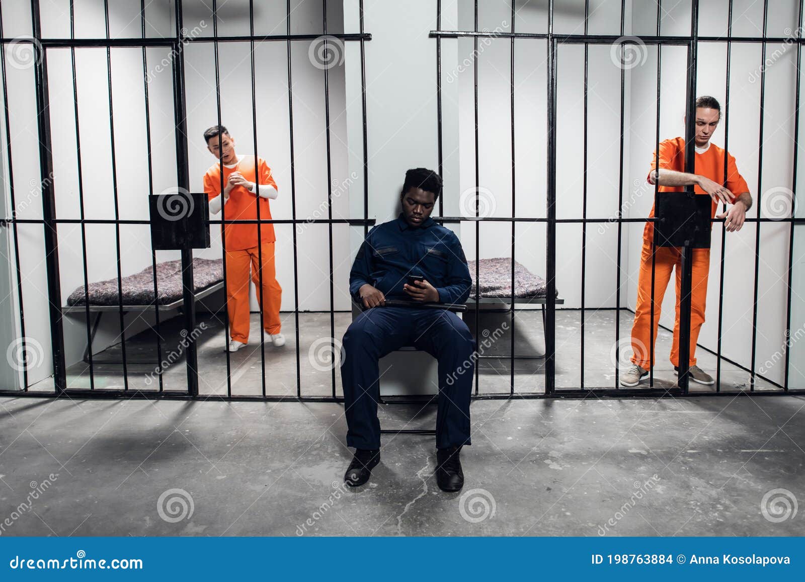 A Strong Black Prison Guard Guards the Cells with Prisoners in the ...