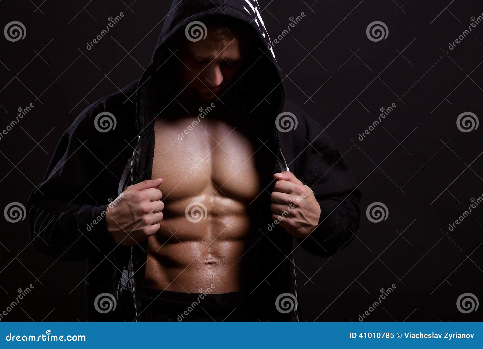 Strong Man in the Hood Showing His Press on Black Background Stock ...