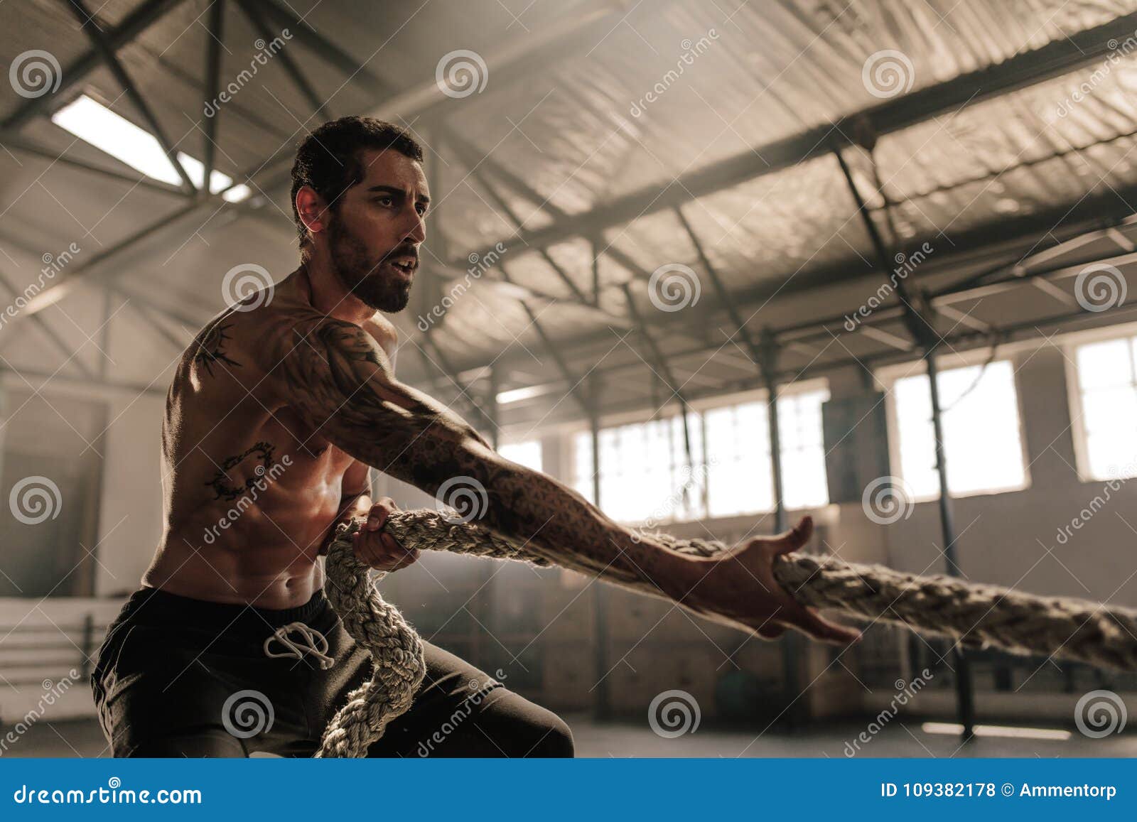 Strong Man Pulling Heavy Rope at Gym Stock Photo - Image of tattoos ...