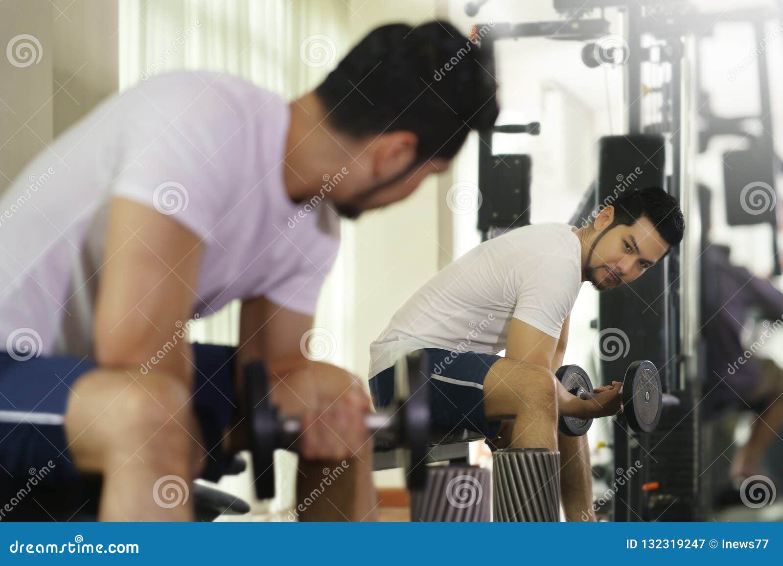 Strong Man Sitting and Workout Lifting Dumbbell for Exercise in Stock ...