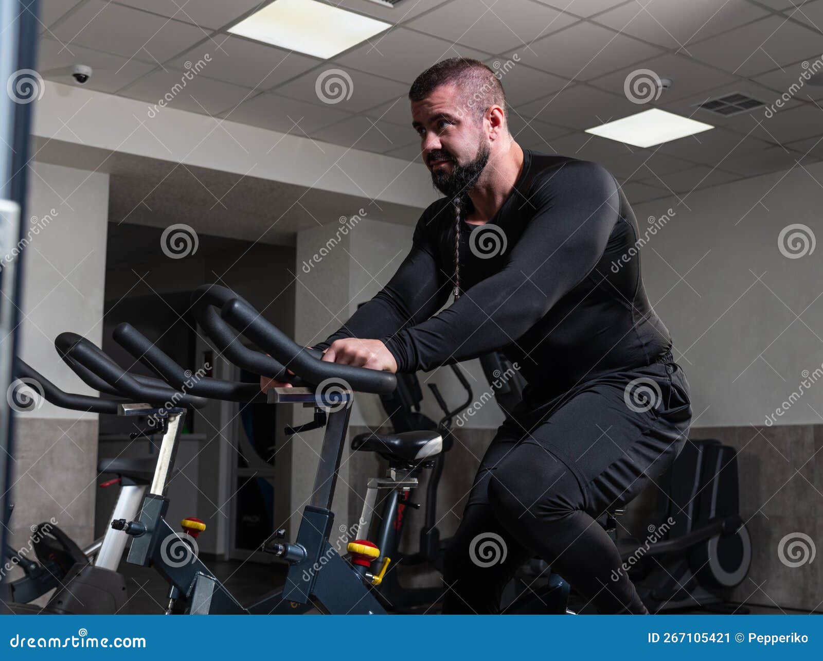 Working Out on the Exercise Bicycle in the Gym Stock Image - Image of ...