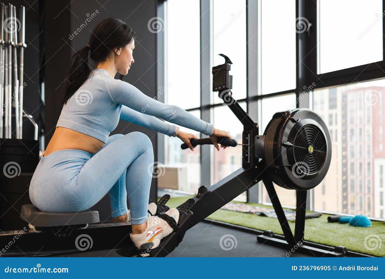Strong Woman is Engaged on a Rowing Machine. Stock Image - Image of ...