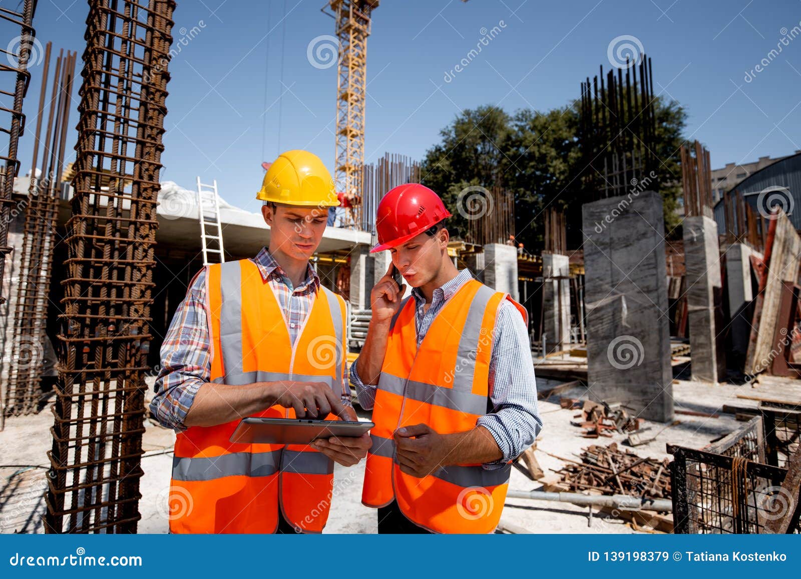 Structural Engineer and Architect Dressed in Orange Work Vests and Hard ...