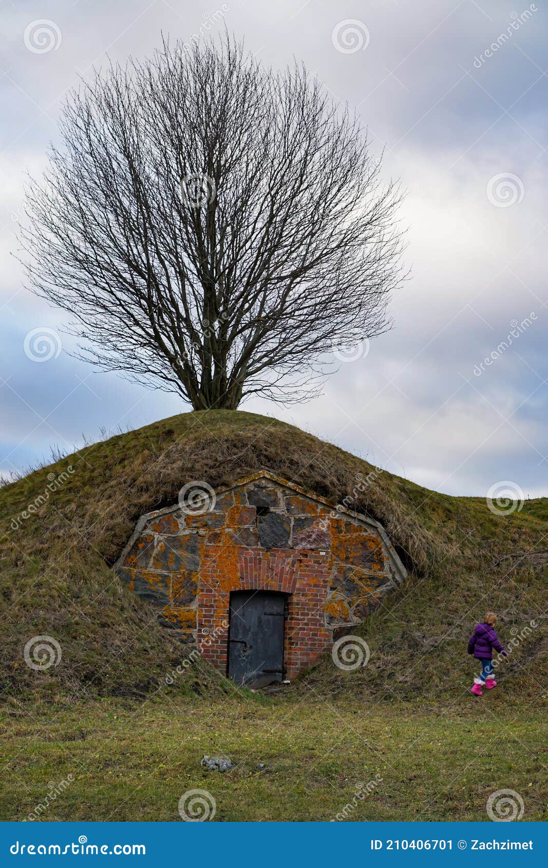 Structure Built into the Side of a Hill with Tree and Child Climbing ...