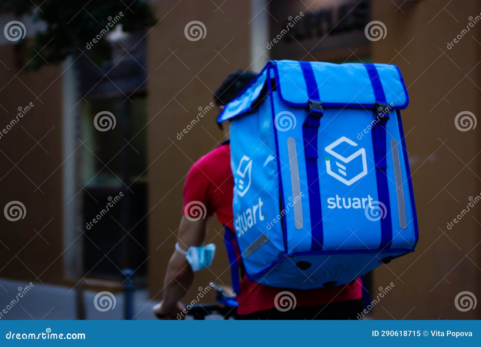 Stuart Delivery Courier Rides Bicycle with an Order in a Backpack ...